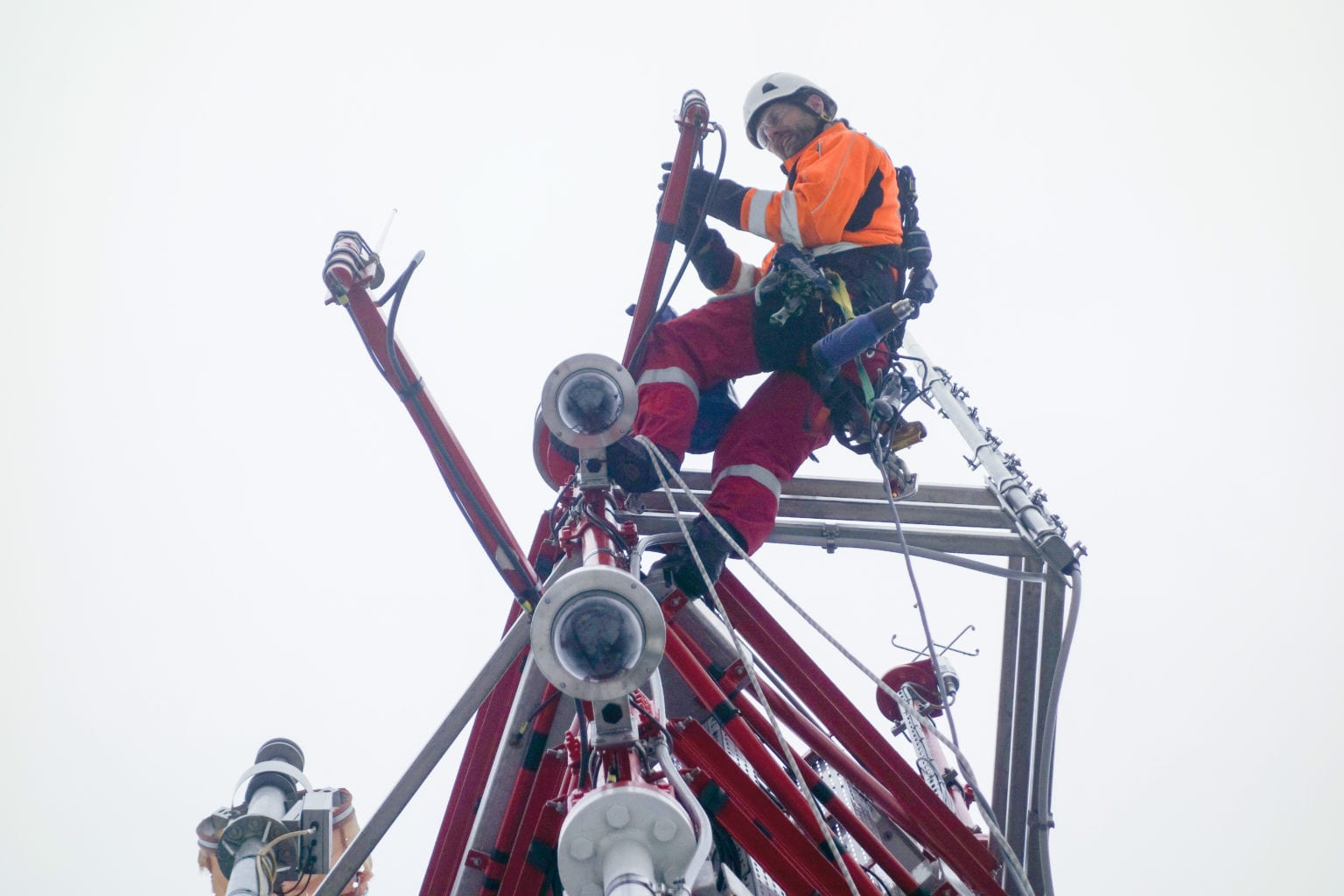 Rope access technician - electrician - working on top of the tower ...